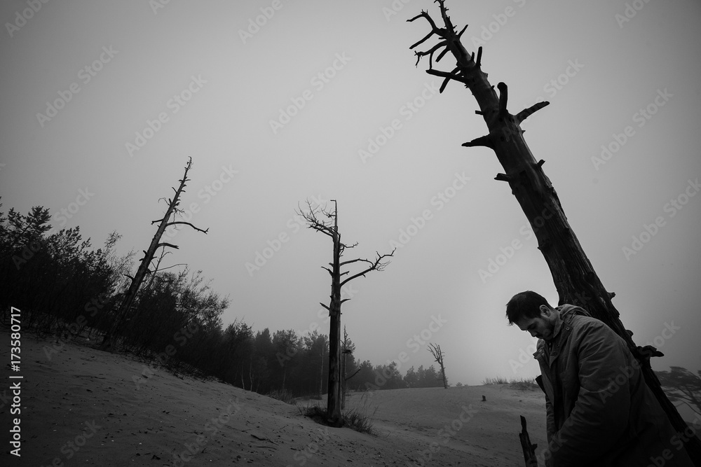 Man with the hung head has leaned the elbows on a dead tree Photos ...