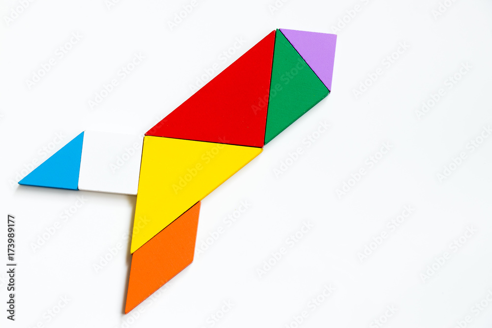 Colorful wood tangram puzzle in rocket or missile shape on white ...