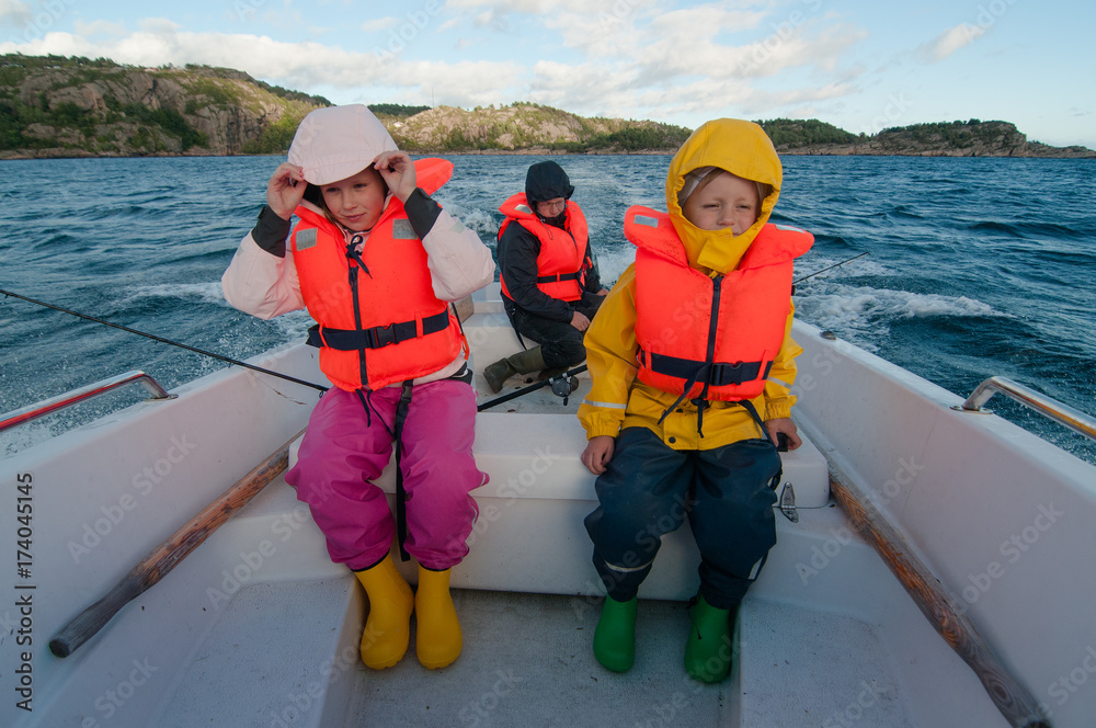 Kids in a floating boat wearing the life vests Stock Photo | Adobe Stock
