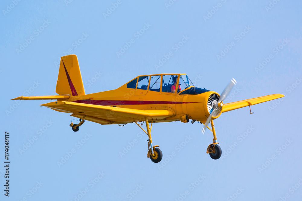 One seat single engine yellow civil utility aircraft Cmelak in blue sky ...