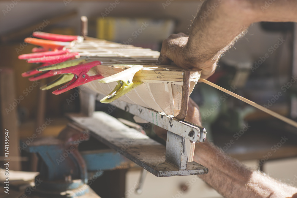 handcrafted craftwork of a wooden boat model / old man working on ...