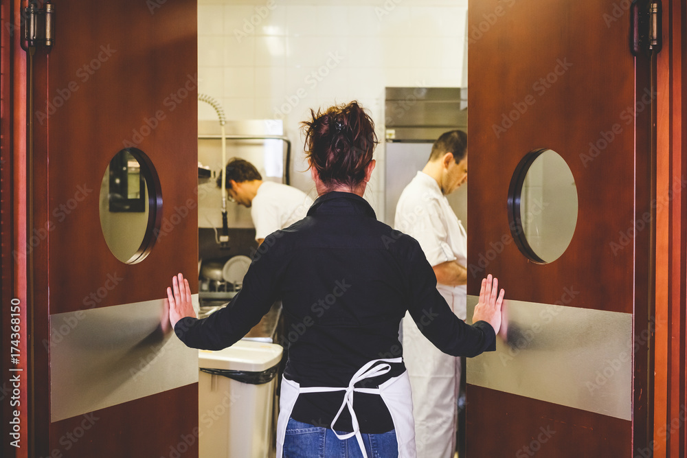Waitress Opening the Doors of the Kitchen in a Restaurant Stock Photo ...