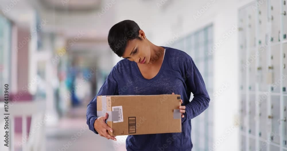 Beautiful black female shaking cardboard box excitedly, guessing what's ...