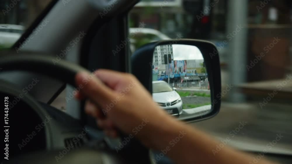 A detailed shot of a driver's hand on the steering wheel as he drives ...