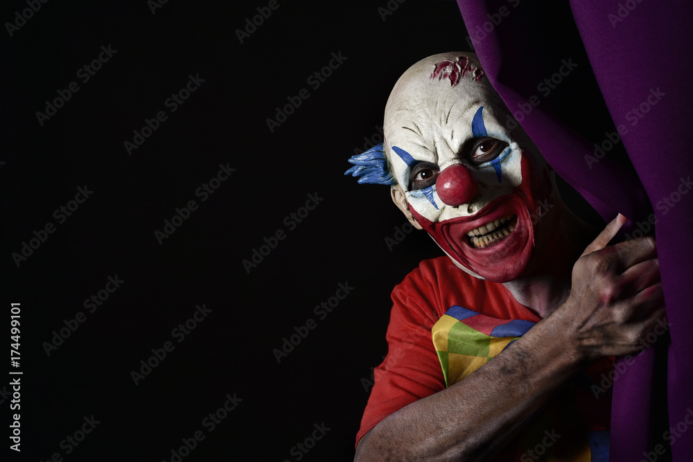 scary evil clown peering out from a stage curtain Stock Photo | Adobe Stock