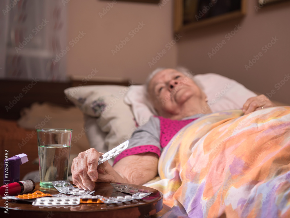 Sick old woman lying in bed at home Stock Photo | Adobe Stock