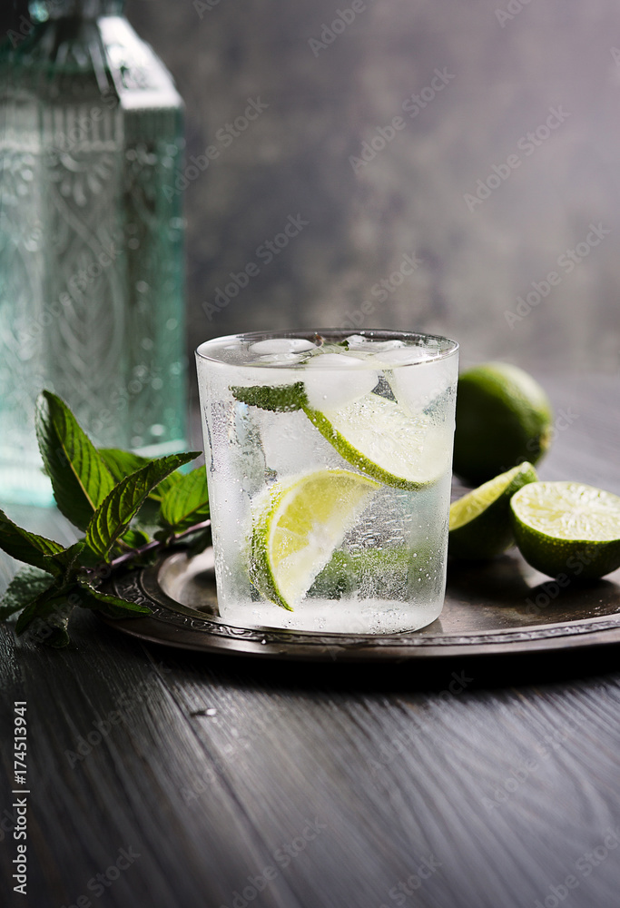 Bicchiere di acqua frizzante fredda con cubetti di ghiaccio e lime su ...