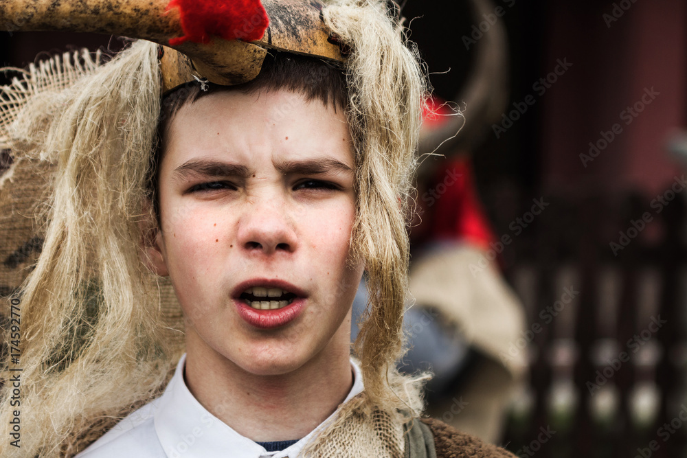 Portrait of young boy in old Slavic dress with traditional mask/Central ...