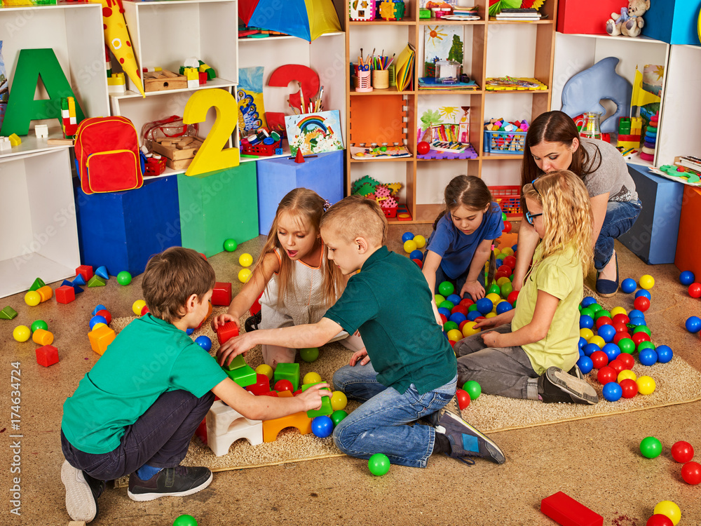 Children building blocks in kindergarten. Group kids playing toy on ...