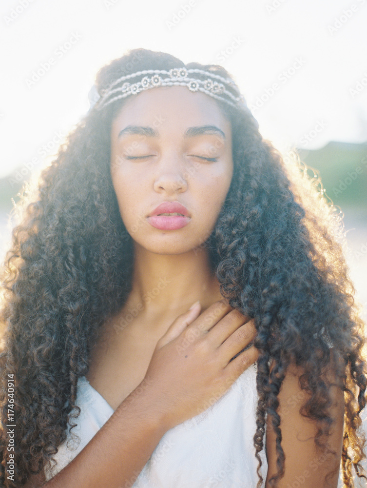 beautiful black bride on beach in gorgeous wedding gown with rocks and ...