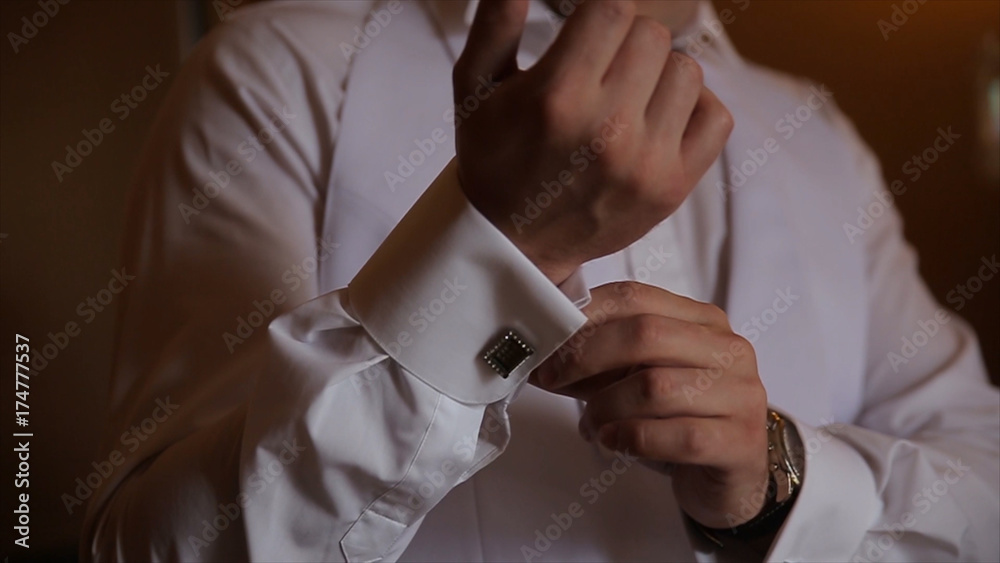 Groom is holding hands on the tie, wedding suit. close up of a hand man ...