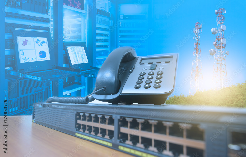 IP telephone on networking switch with blurred server rack cabinet data ...