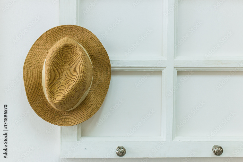 Hang Your Hat woven straw hat hanging on a wall rack Stock Photo ...