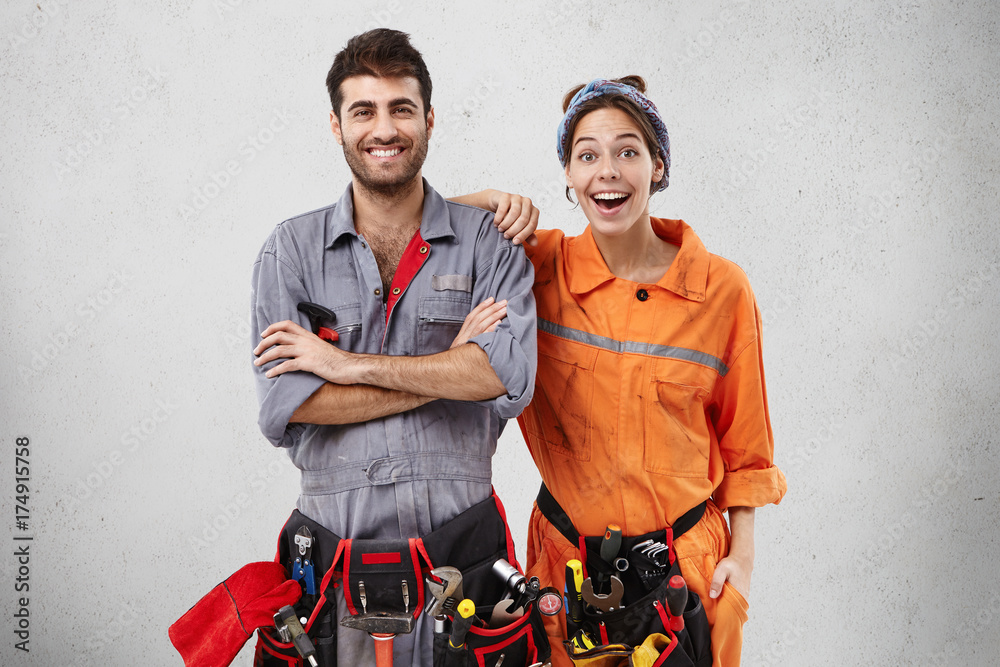 Foto de Happy excited female and male plumber wear uniform with tool ...