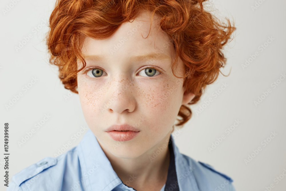 Close up portrait of funny little kid with orange hair and freckles ...
