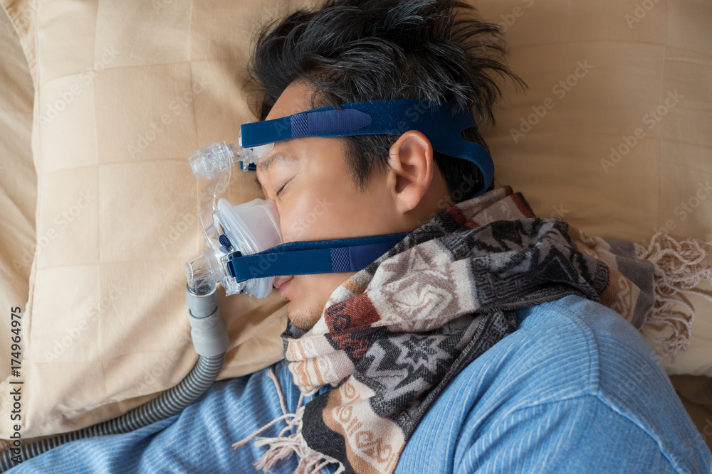 Man laying in bed wearing CPAP mask ,healthcare concept.Middle aged man ...