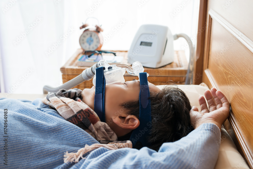 Man laying in bed wearing CPAP mask ,healthcare concept..Middle aged ...
