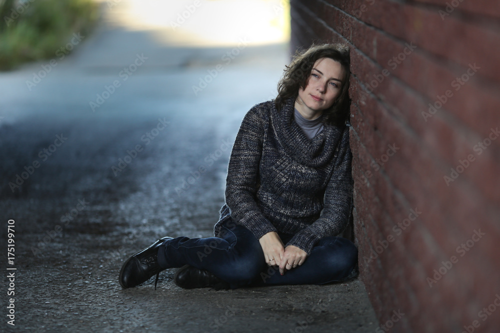 Woman Sitting Against Wall