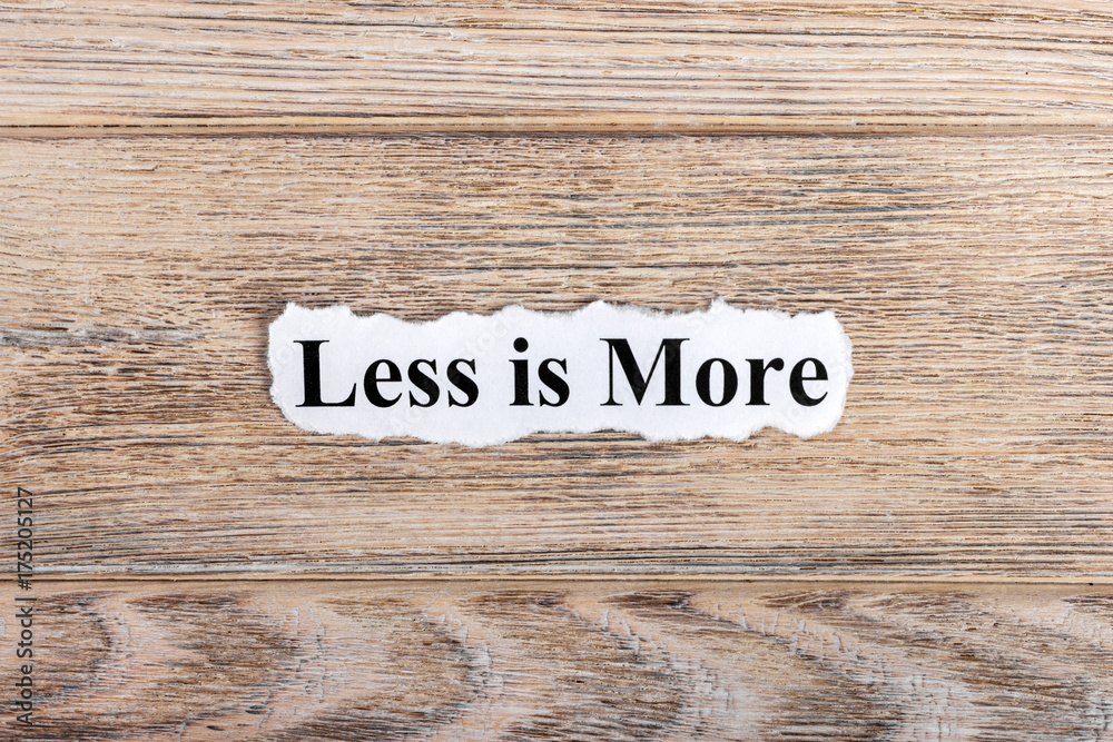 less is more text on paper. Word less is more on torn paper. Concept ...