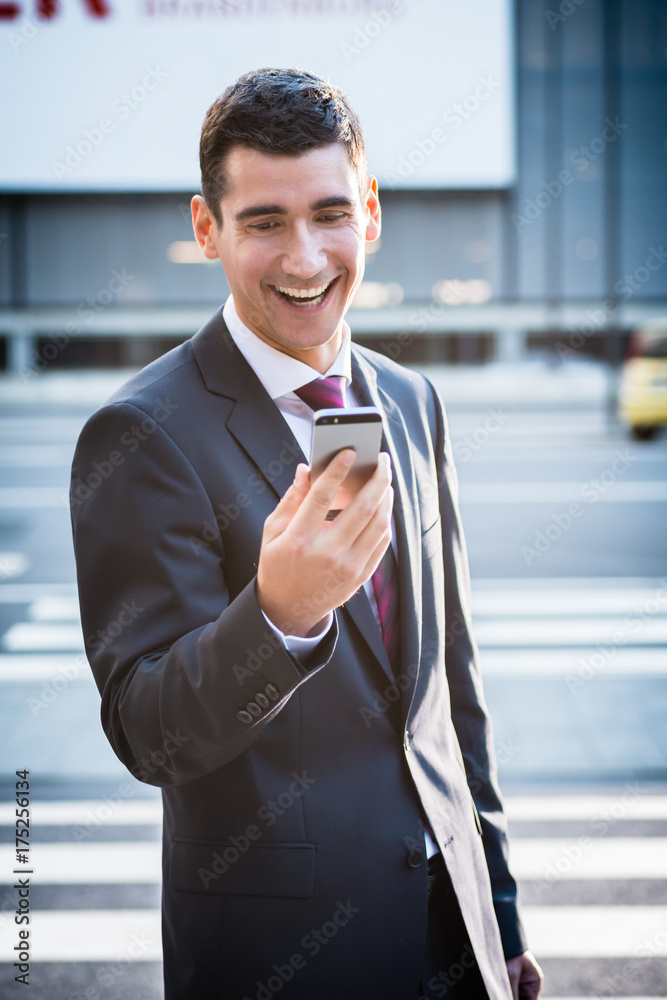 Business man reading email on phone crossing street on zebra strip ...