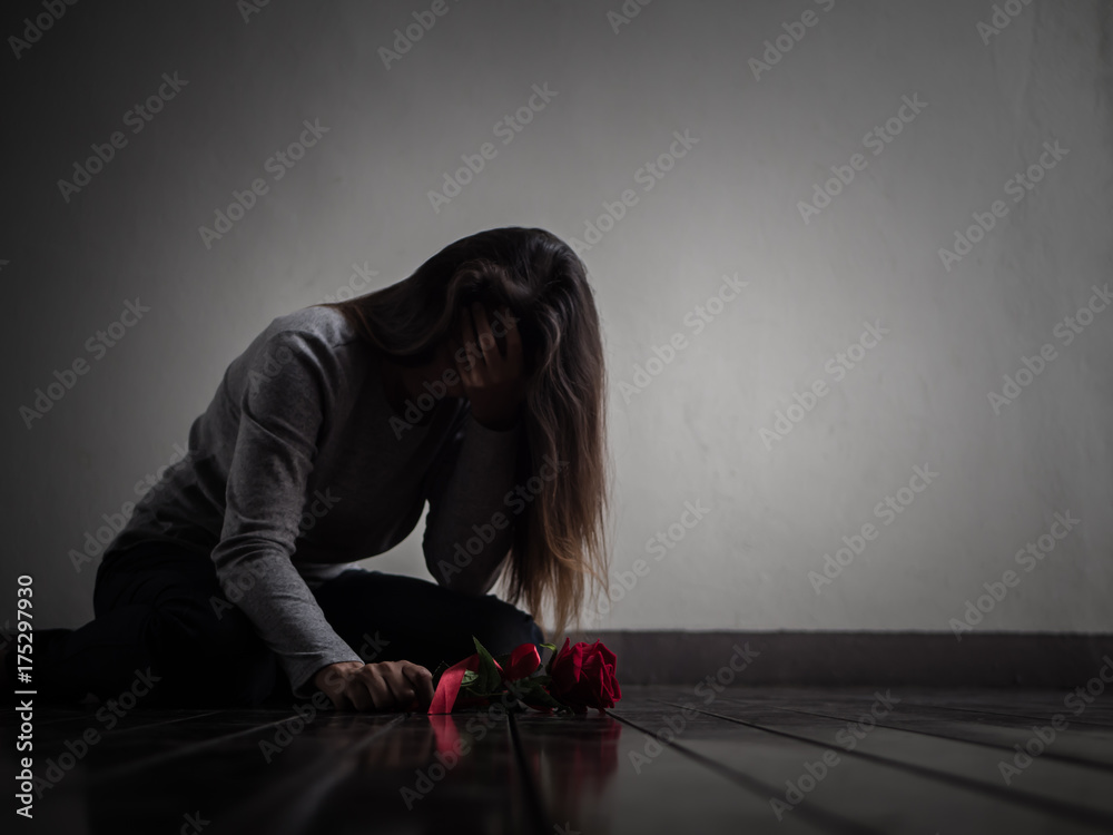 Sad woman sitting and crying with red rose in her hand. Lonly , love ...