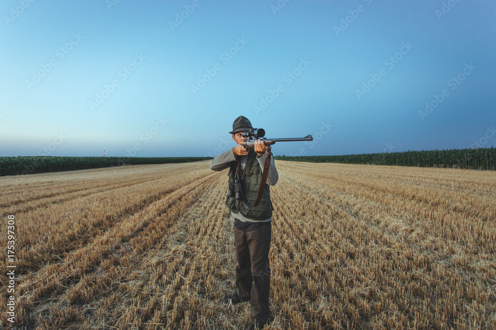 Hunter aims in field with his riffle Stock Photo | Adobe Stock