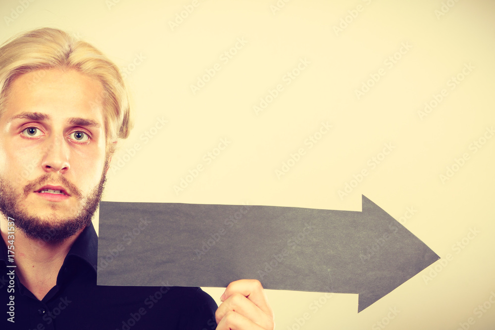 Man holding black arrow pointing right Stock Photo | Adobe Stock