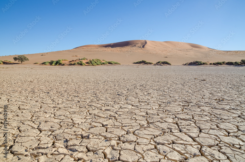 Beautiful towering red sand dunes and dry cracked clay surface at ...