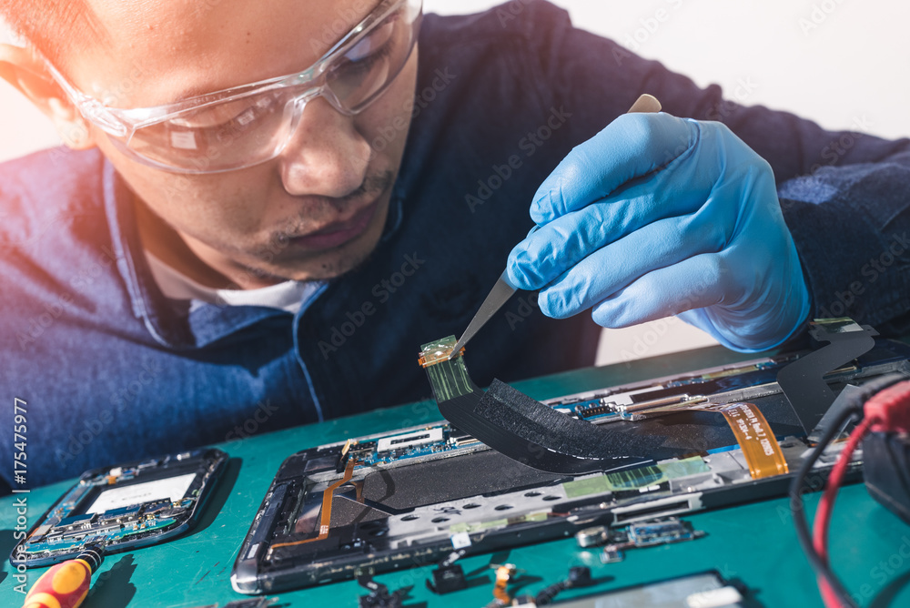 The abstract image of the asian technician repairing a tablet in the ...
