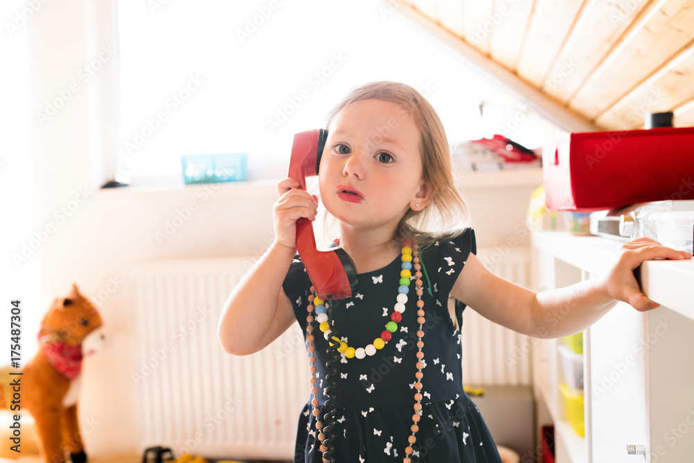 Cute little girl in dress wearing red lipstick making phone call Stock ...