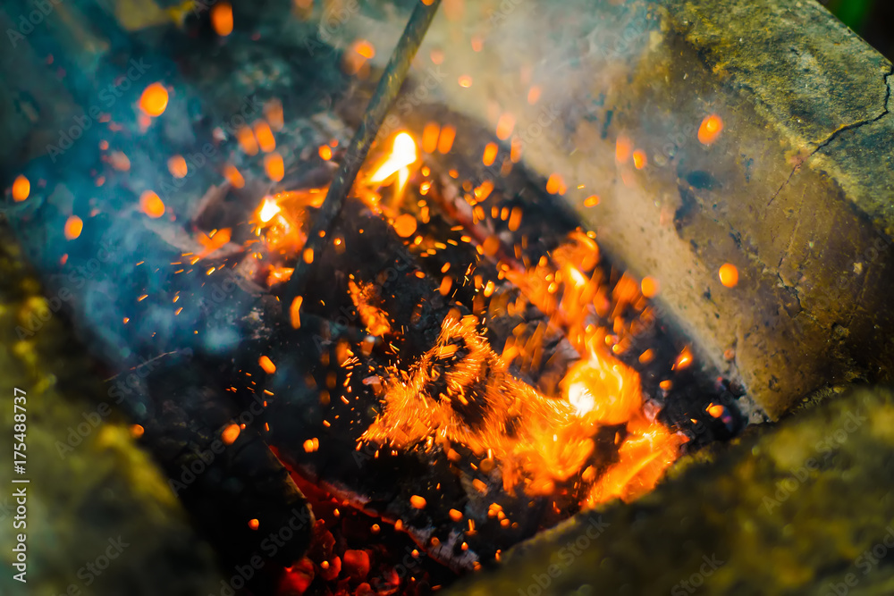 Hot sparking live-coals burning in a barbecue. small depth of field ...