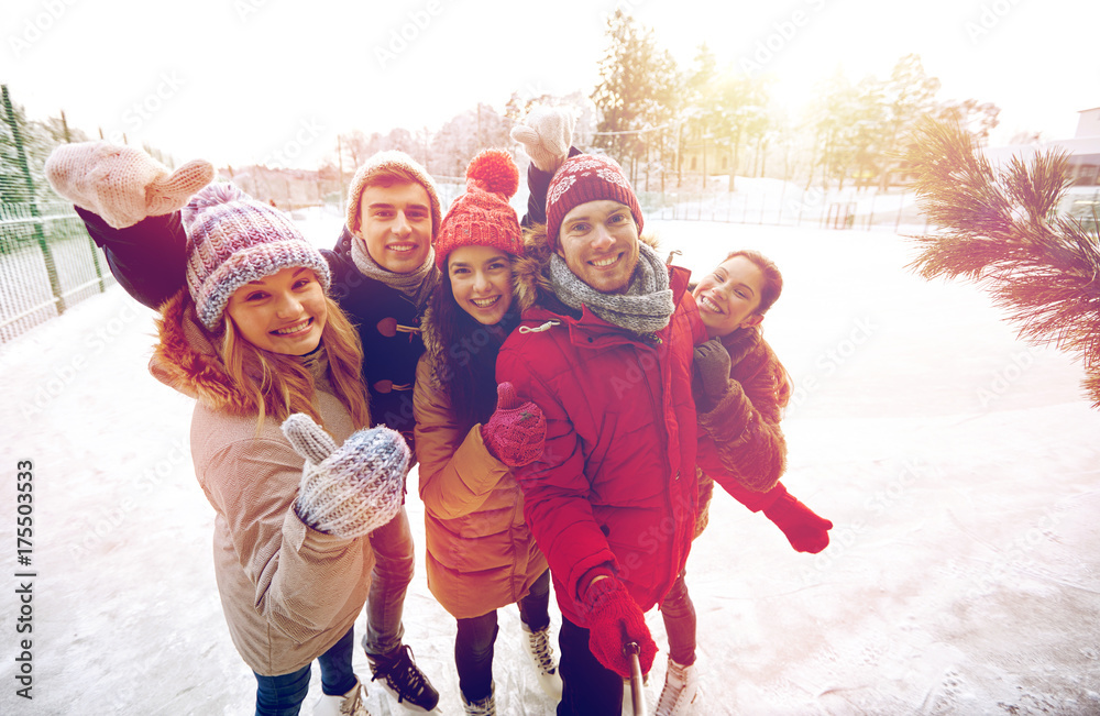 happy friends with smartphone on ice skating rink Stock-Foto | Adobe Stock