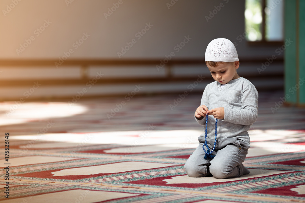 The Muslim child prays in the mosque, the little boy prays to God ...
