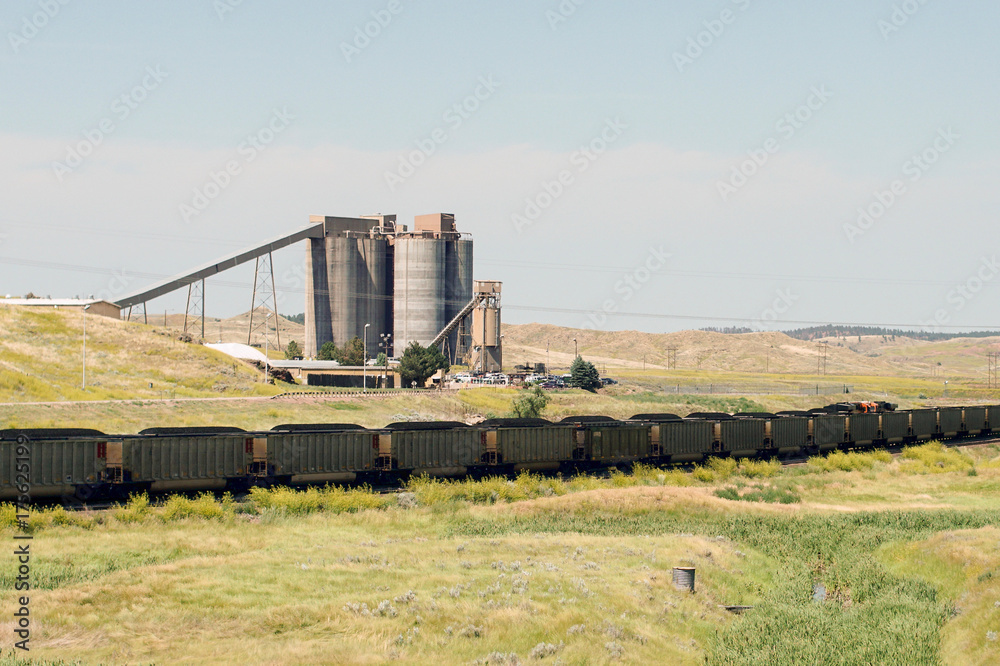 Long coal mine train with coal silos in the background Stock Photo ...