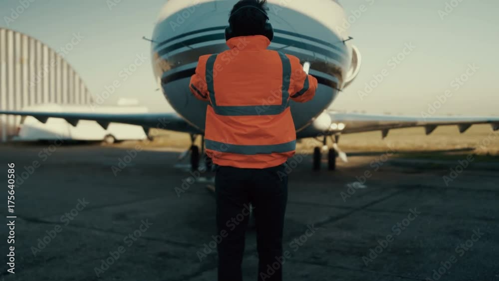 Airport worker signaling to airplane pilot on the runway. Stock Video ...