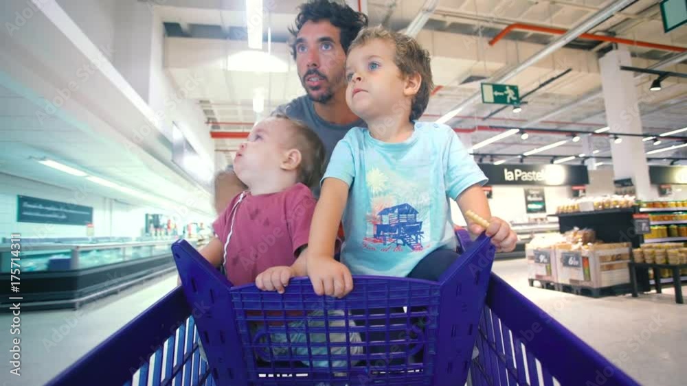 Father shopping in the supermarket with childs inside de chart shopping ...