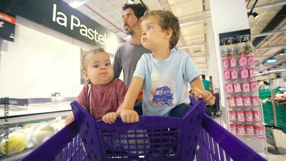 Father shopping in the supermarket with childs inside de chart shopping ...