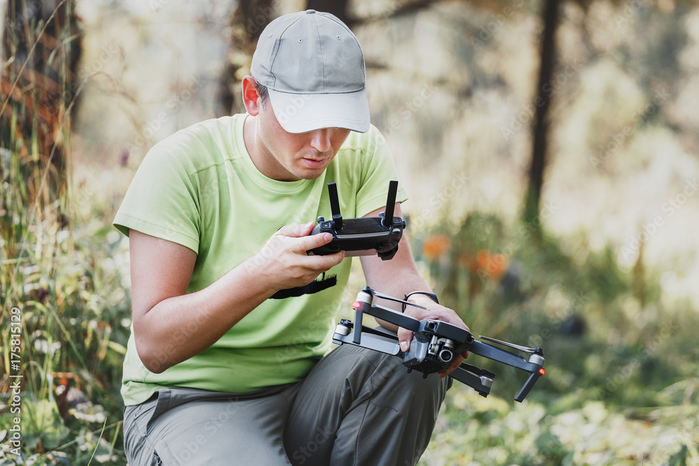 closeup on male hands of drone operator with an amateur quadcopter ...