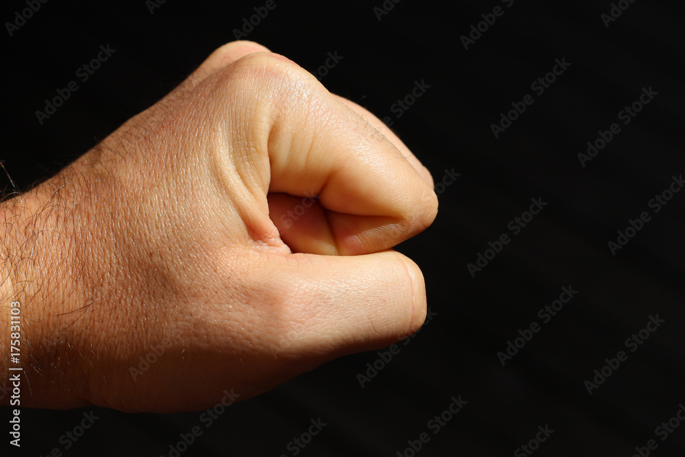 Male clenched fist isolated on dark background. This photo can be used ...