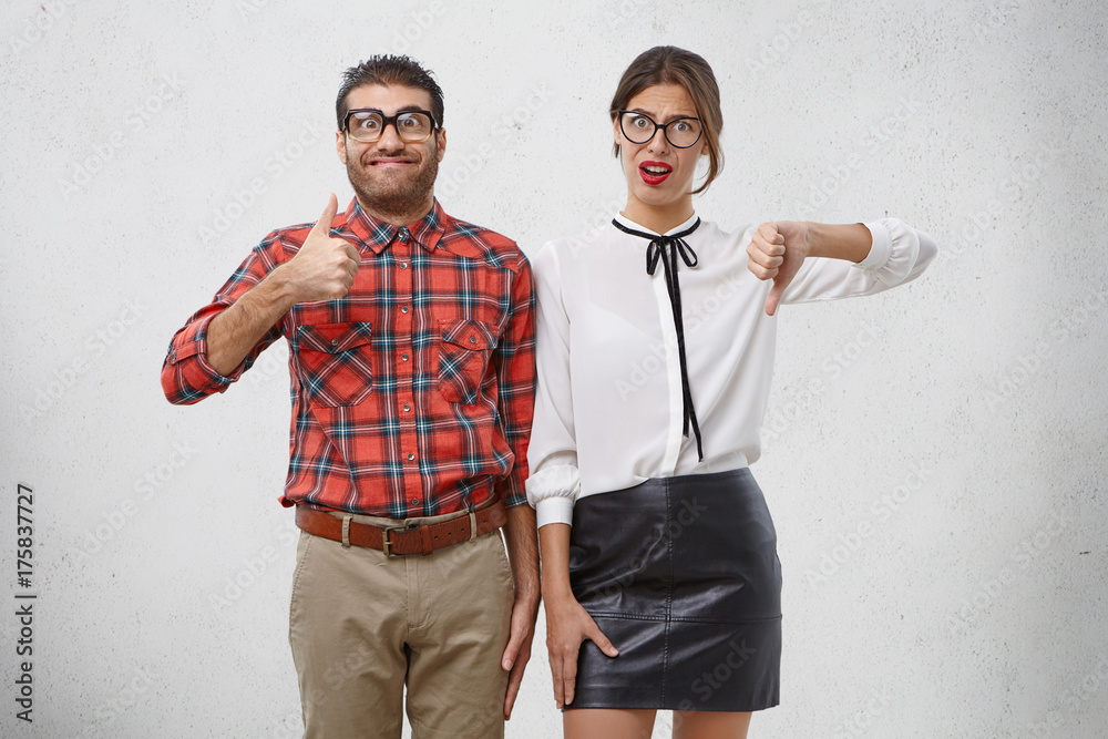 People, facial expressions and body language concept. Happy geek male raises thumb in joy being ...