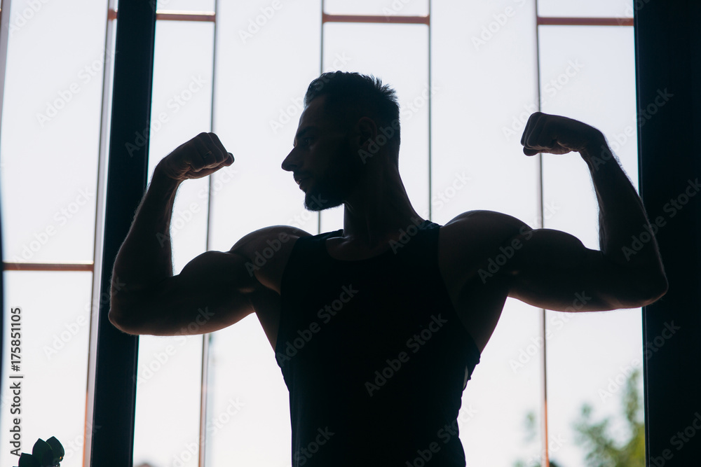 Young athlete posing with a torso for photography on a brick wall ...