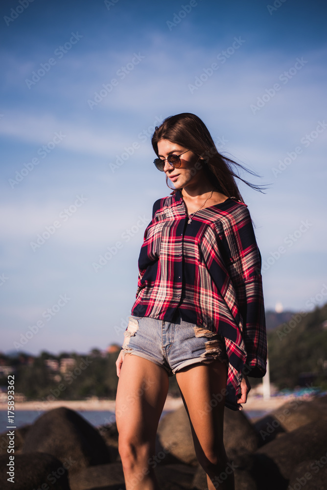 Sexy Girl in flannel shirt on the rocky beach. Stock Photo | Adobe Stock