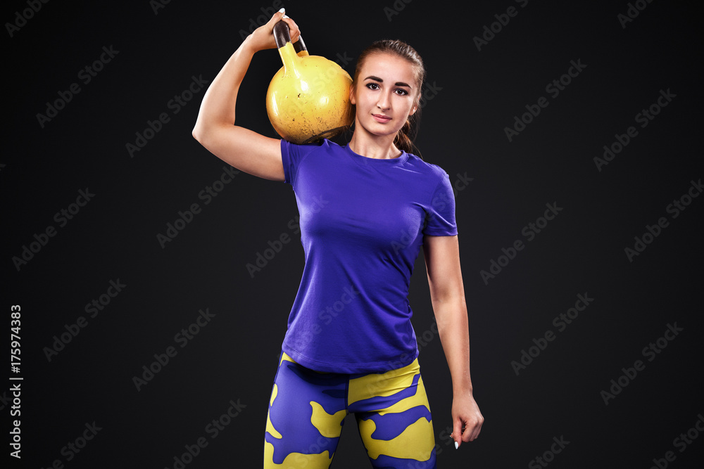 Sporty beautiful woman with dumbbell exercising at black background to ...