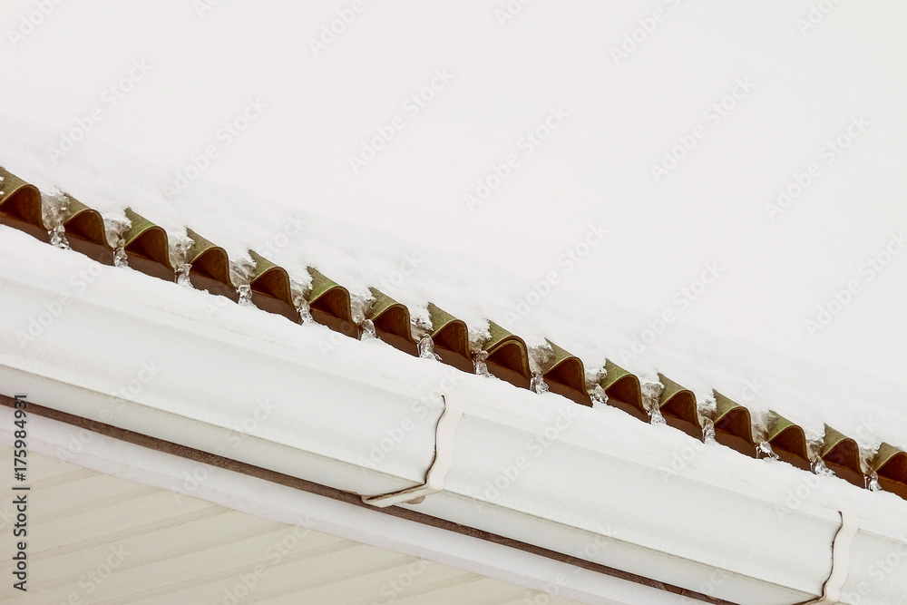 Snow-covered icy roof overhang with gutter. Frozen drain. Stock Photo ...