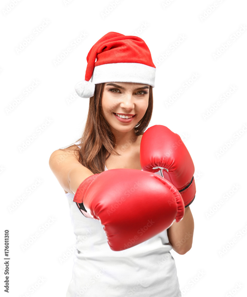 Beautiful young woman in Santa Claus hat and boxing gloves on white ...