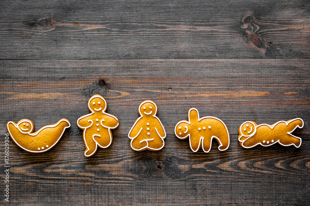 Gingerbread cookies in shape of yoga asanas on dark wooden background ...