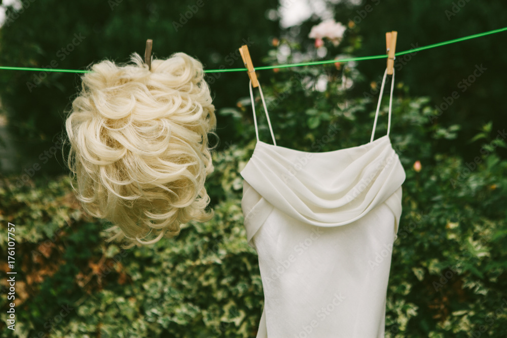 Blonde wig and white dress hanging on a washing line to dry Stock Photo ...
