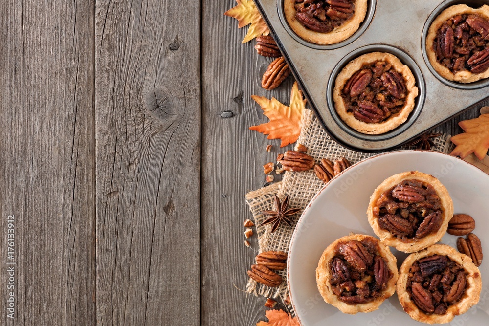 Autumn baking scene side border with pecan tarts, leaves and nuts over ...