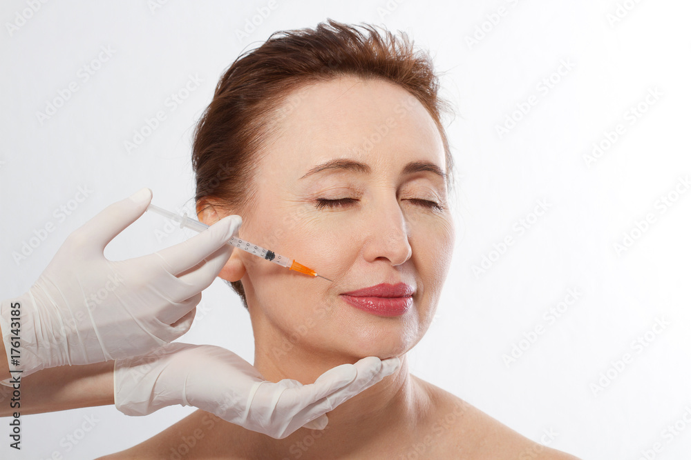 Middle age woman 40s getting lifting botox injection in lips by doctor ...