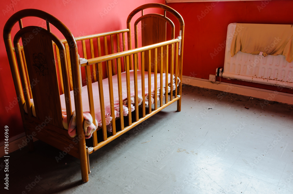 Child's cot in a dirty, empty room Stock Photo | Adobe Stock